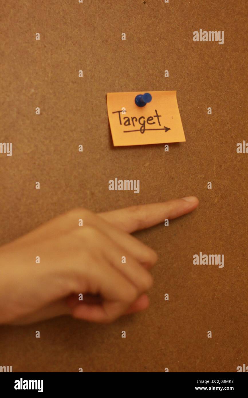 Target text written on sticky note concept designed with woman hand ...