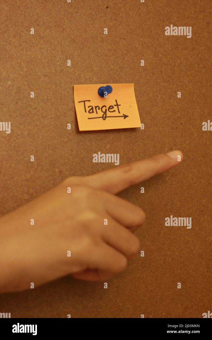 Target text written on sticky note concept designed with woman hand ...