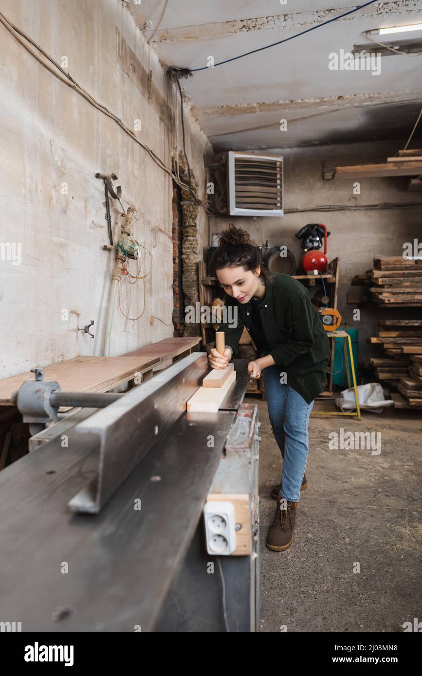Tattooed woodworker working with plank and jointer machine Stock Photo ...
