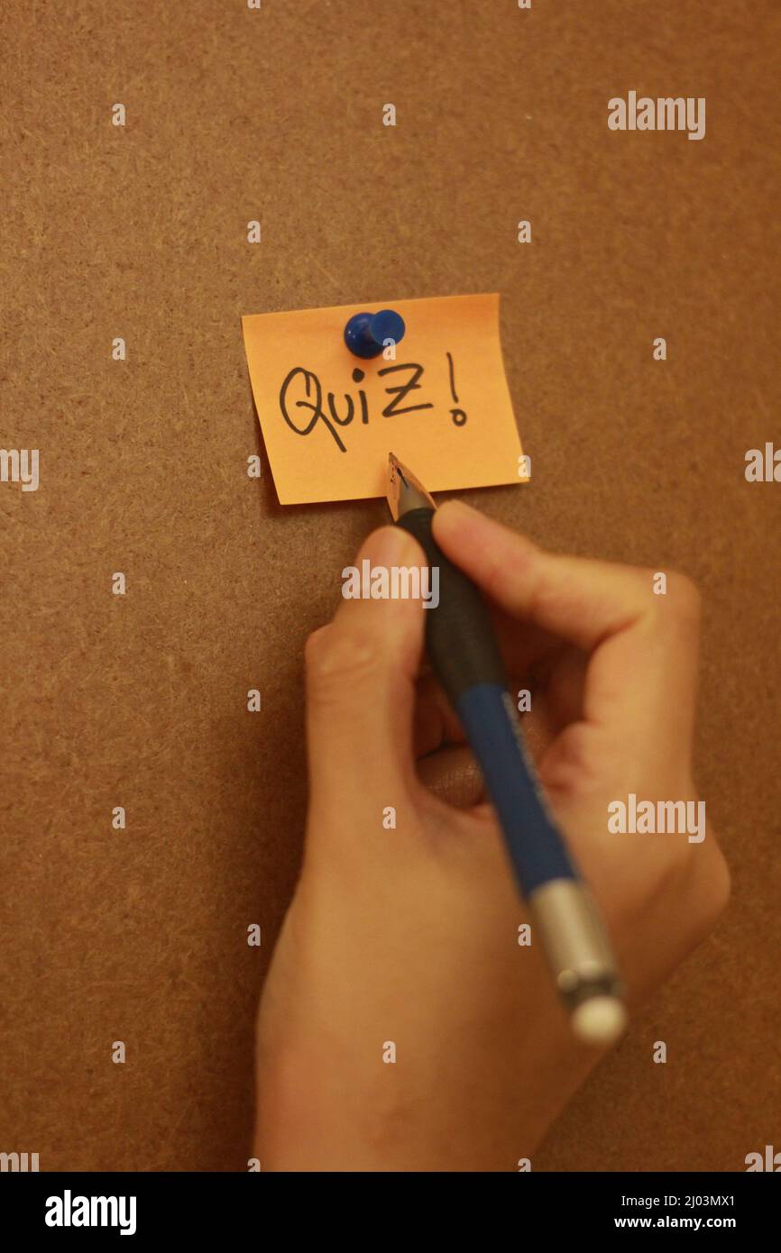Quiz written on sticky note concept designed with woman hand Stock ...