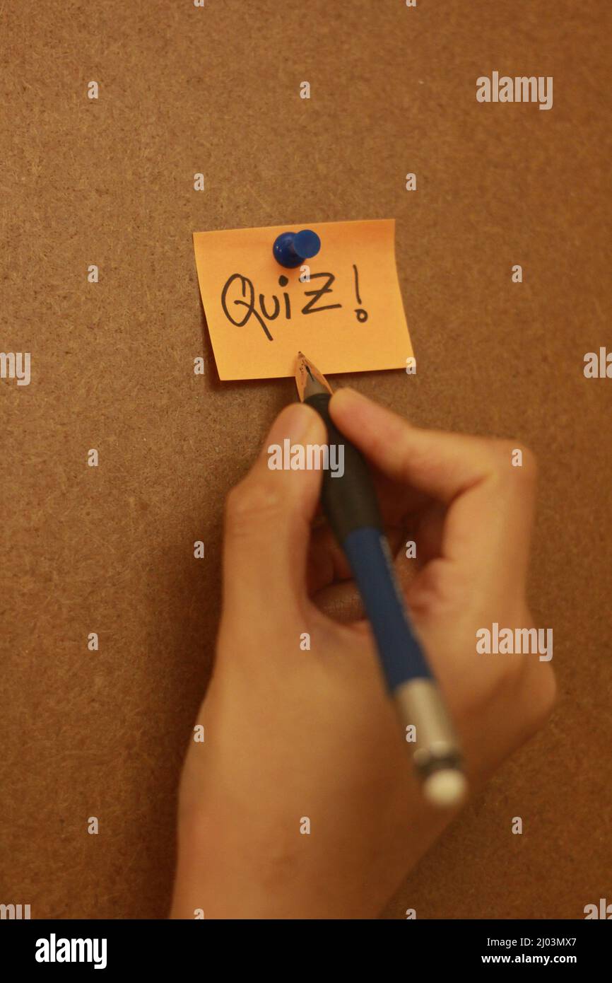 Quiz written on sticky note concept designed with woman hand Stock ...