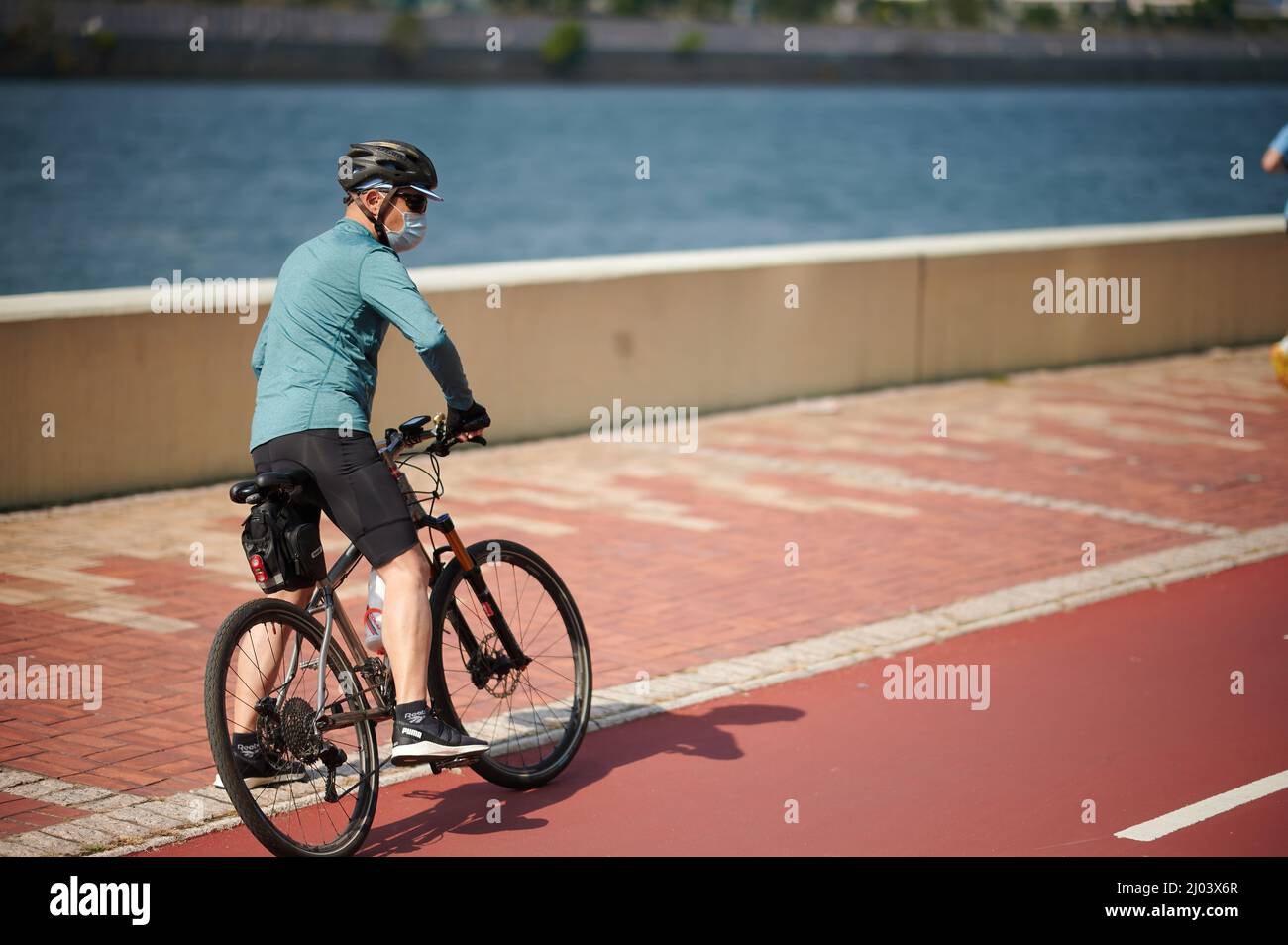 Male riding bicycle next to Shing Mun river in Hong Kong Stock Photo ...