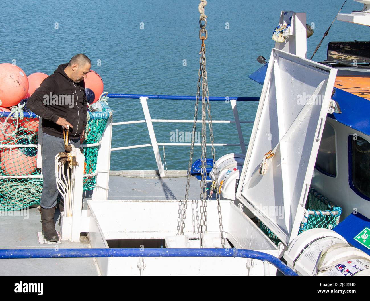 Fisherman unloading boxes of fish from fishing trawler fish hold Stock ...