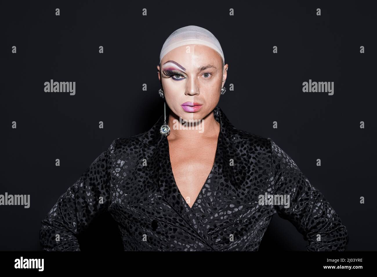 man in blazer, with half face makeup, looking at camera isolated on ...