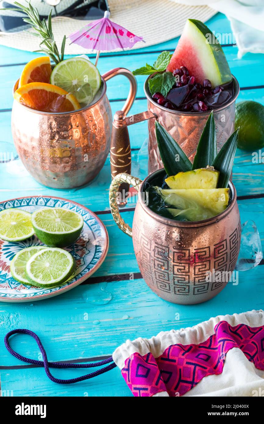 Three cold refreshments with fresh fruit garnishment, ready for ...