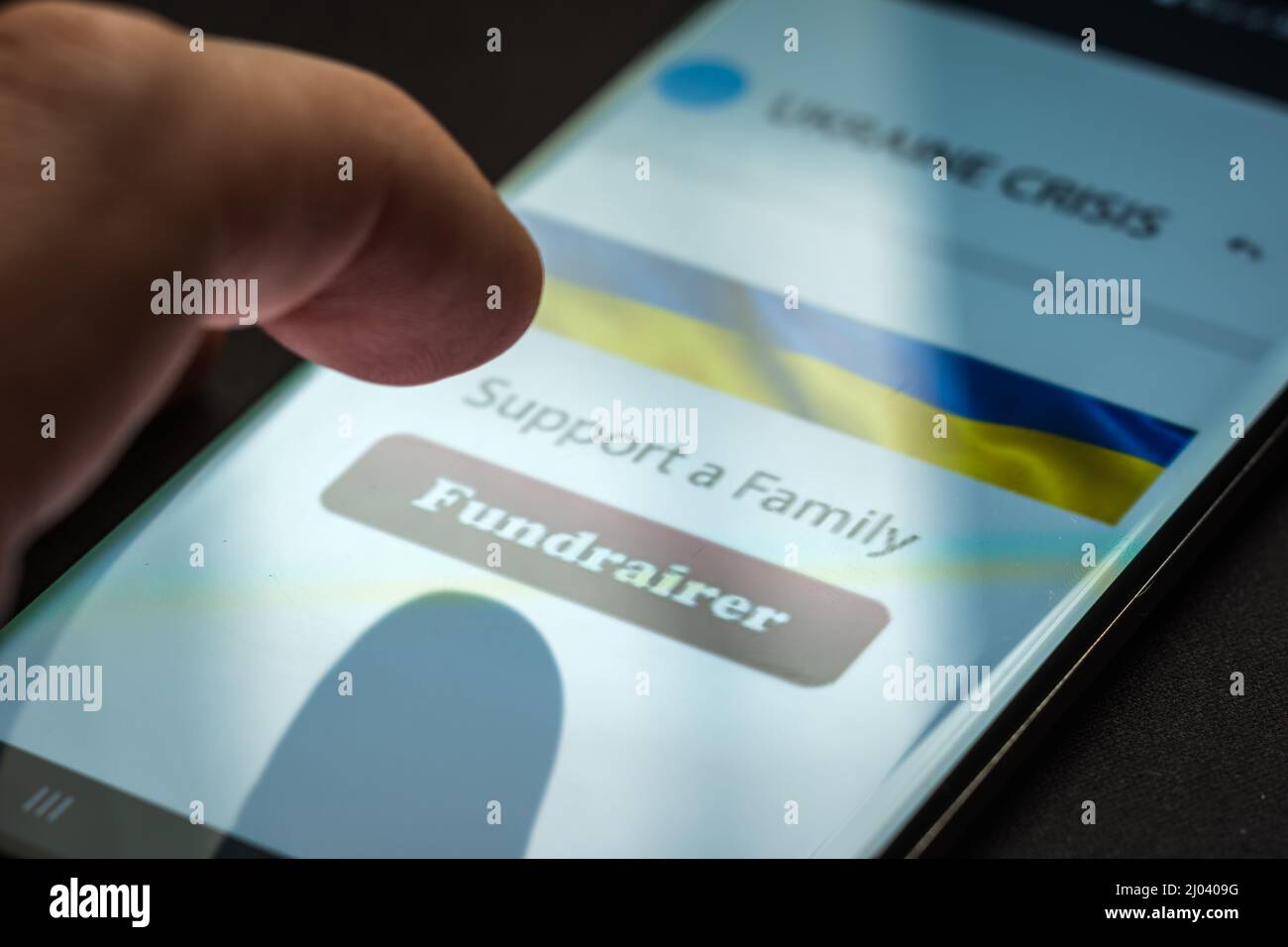 Close-up finger pressing fundraiser button on smartphone screen ...