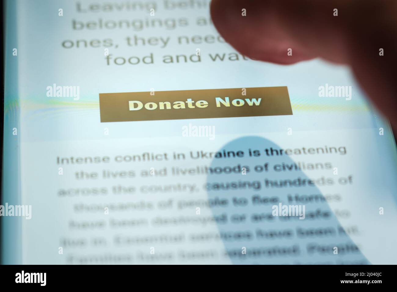 Close-up finger pressing donate icon button on smartphone screen ...