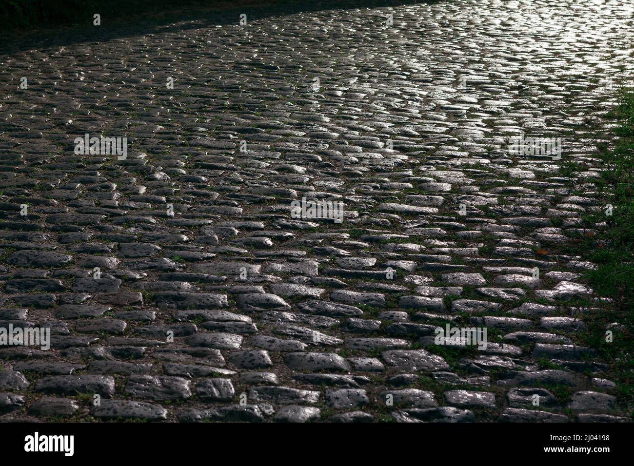 Cobblestone road with sun light . Old town pavement Stock Photo - Alamy