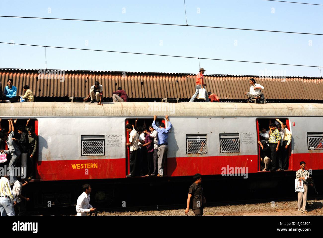 Indian commuters travel on the roof of a train performing stunts on ...