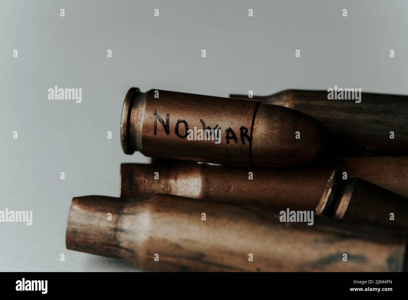 a bunch of used bullet shells on a gray surface and a bullet with the ...