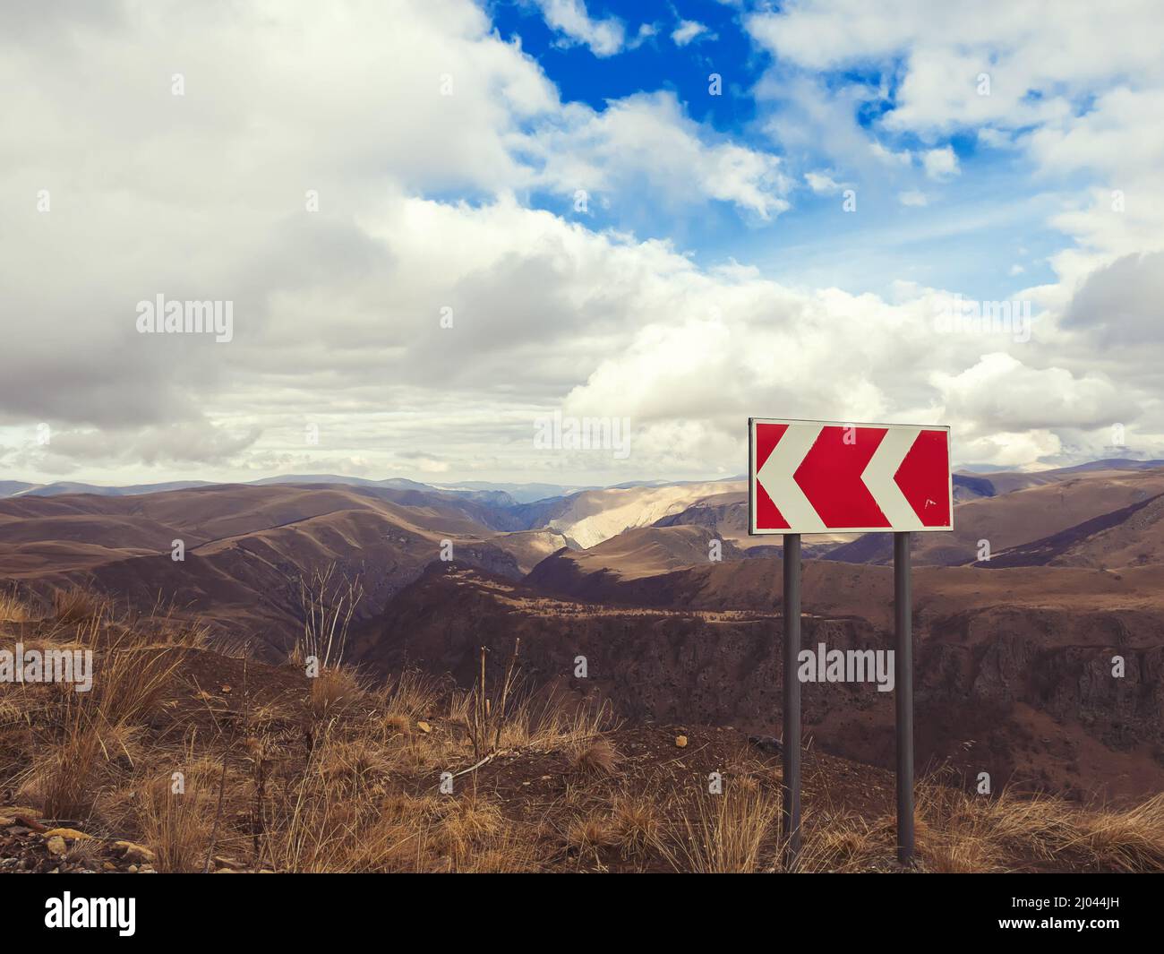 A road sign with red-white arrows against the background of Caucasian ...