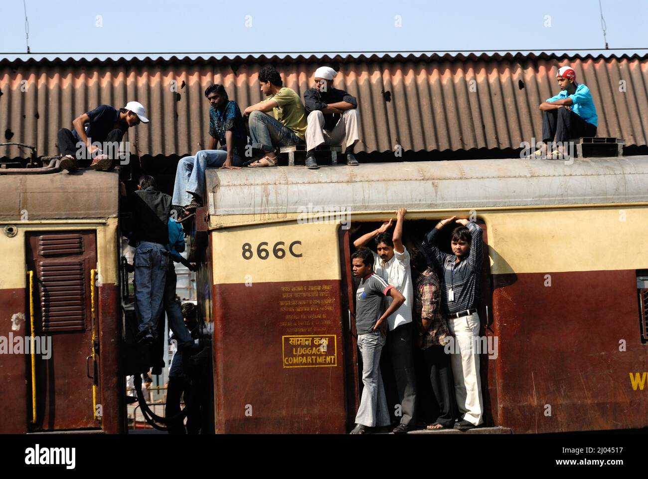 Indian commuters travel on the roof of a train performing stunts on ...
