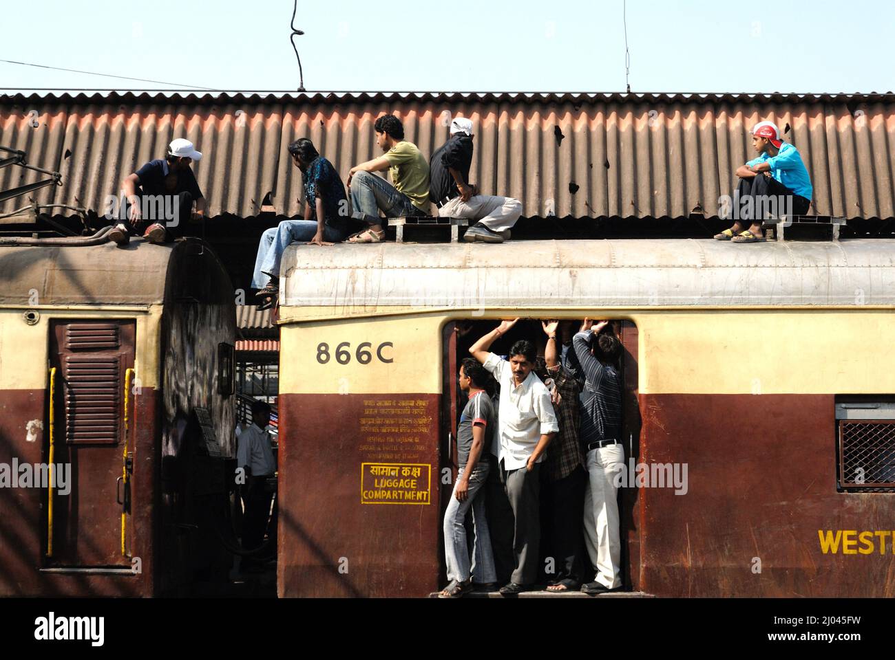 Indian commuters travel on the roof of a train performing stunts on ...