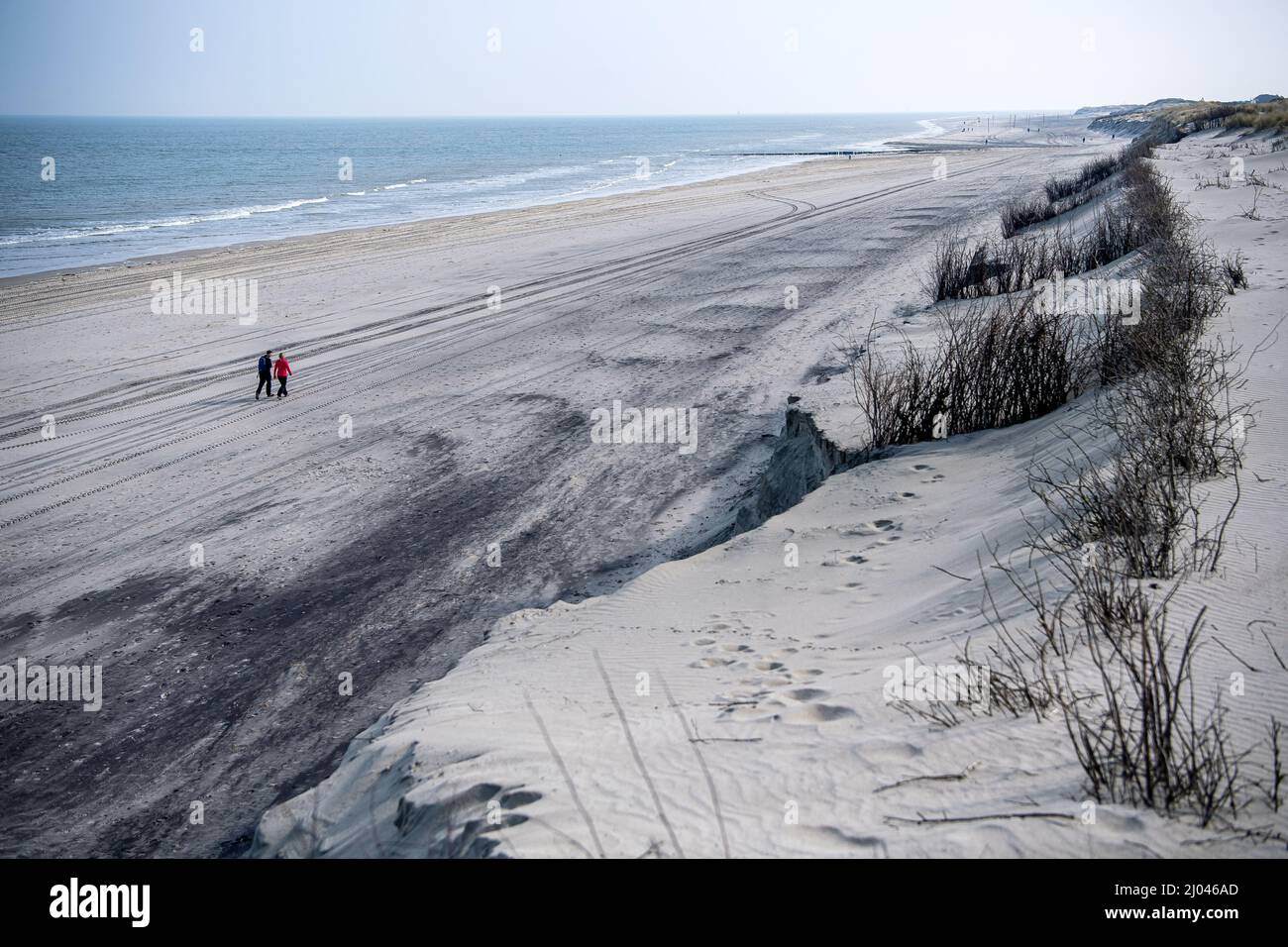 Wangerooge, Germany. 16th Mar, 2022. Walkers walk along the break-off ...
