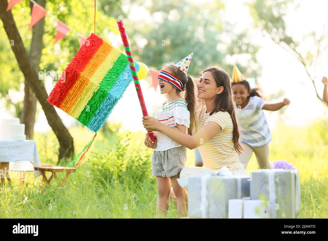 Woman and cute children at pinata birthday party Stock Photo - Alamy