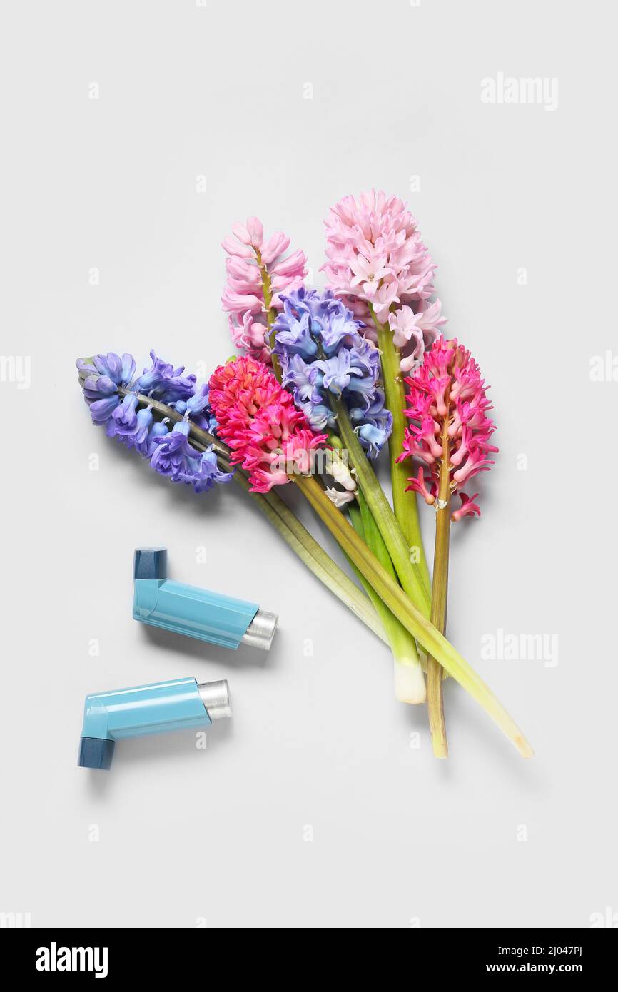 Bouquet of beautiful hyacinth flowers and inhalers on white background ...