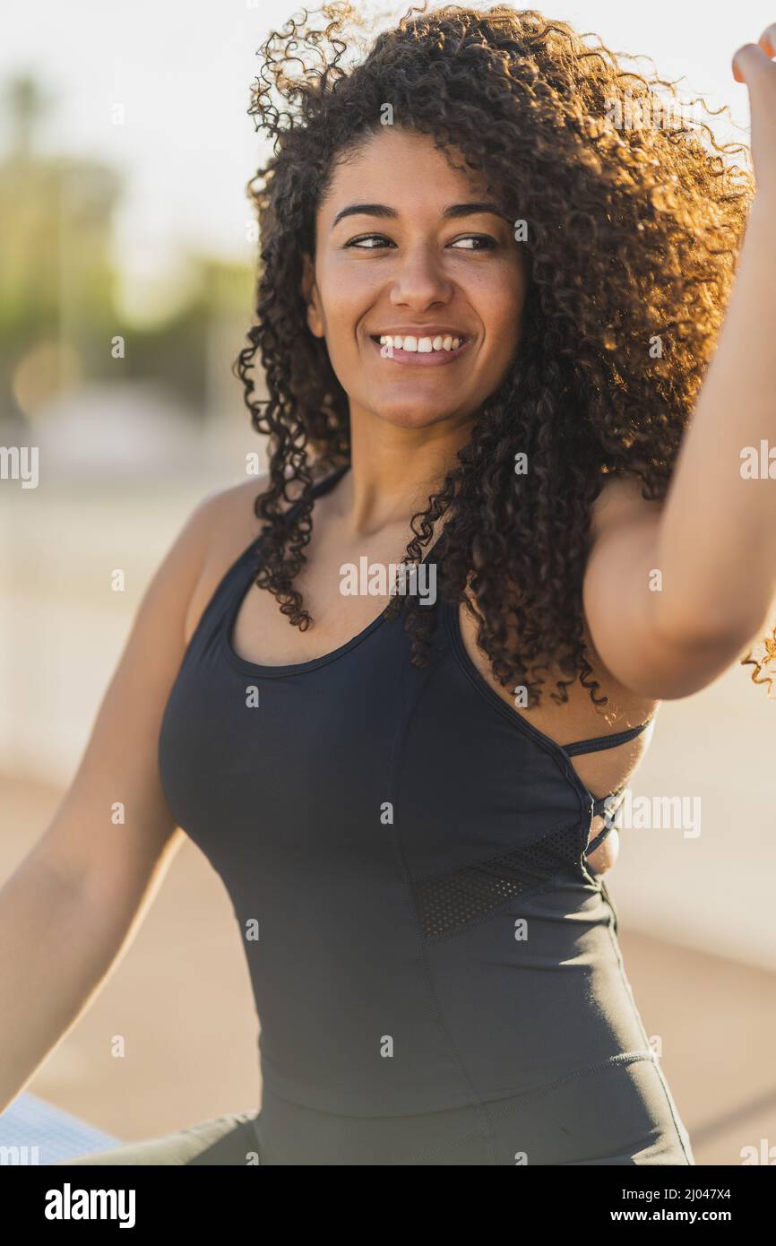 Vertical shallow focus of a mixed-race young woman smiling and looking ...
