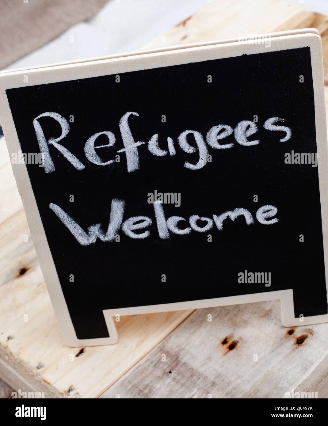 Refugees welcome handwritten on a chalkboard Stock Photo - Alamy