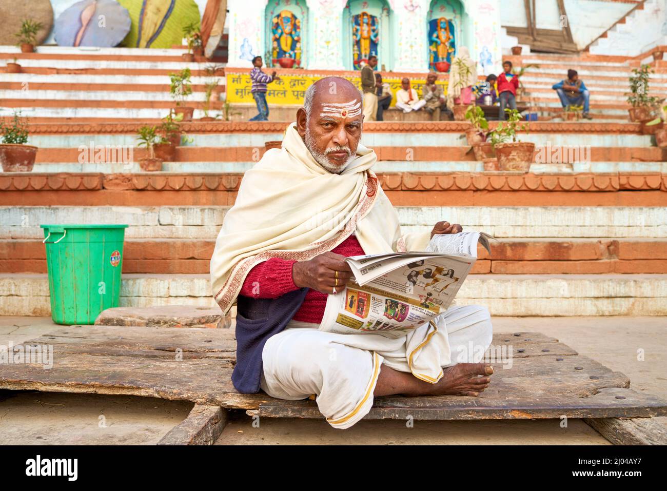 India. Varanasi Benares Uttar Pradesh. A man reading newspaper by the ...