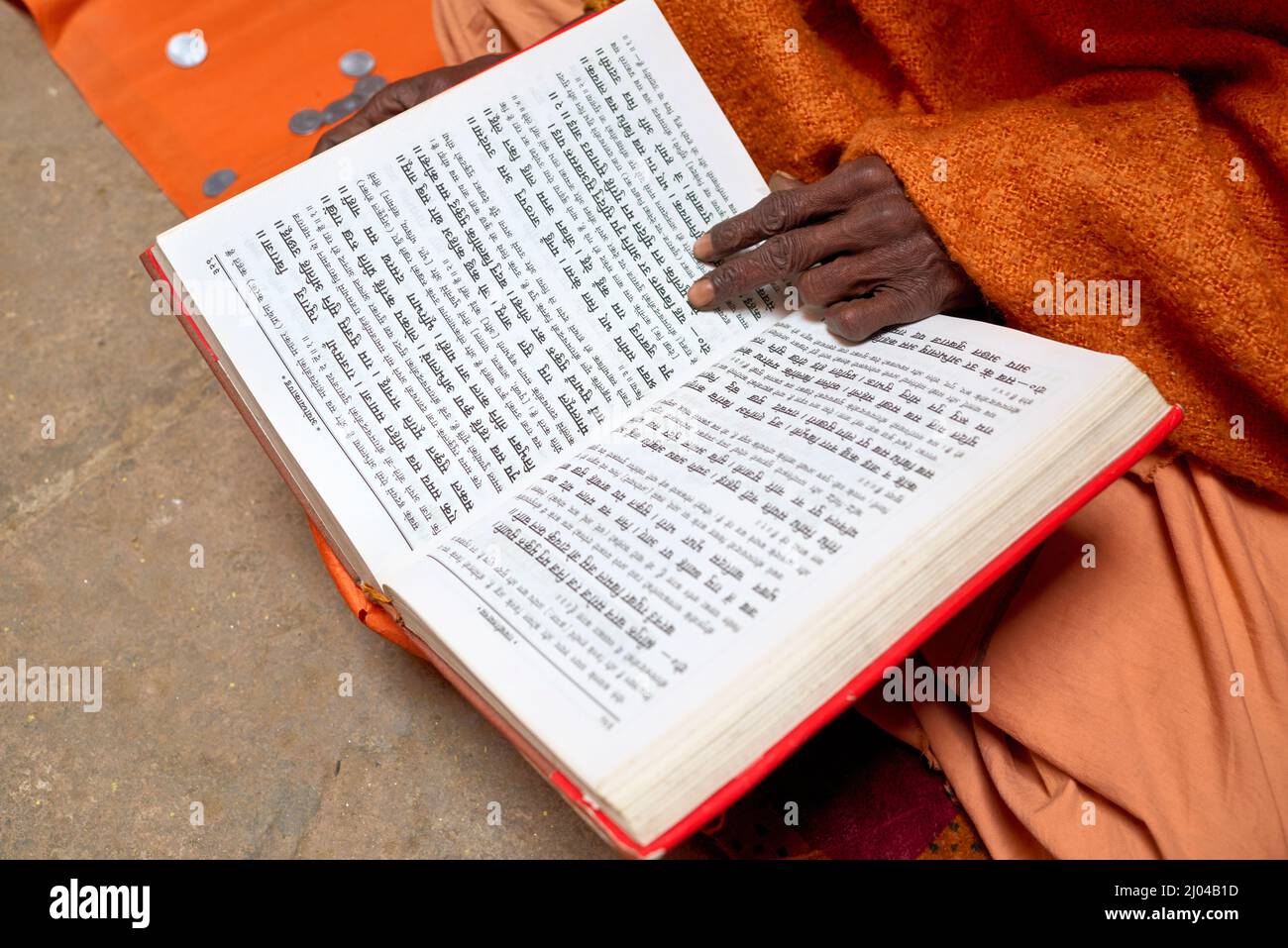 India. Varanasi Benares Uttar Pradesh. A man reading sacred texts of ...