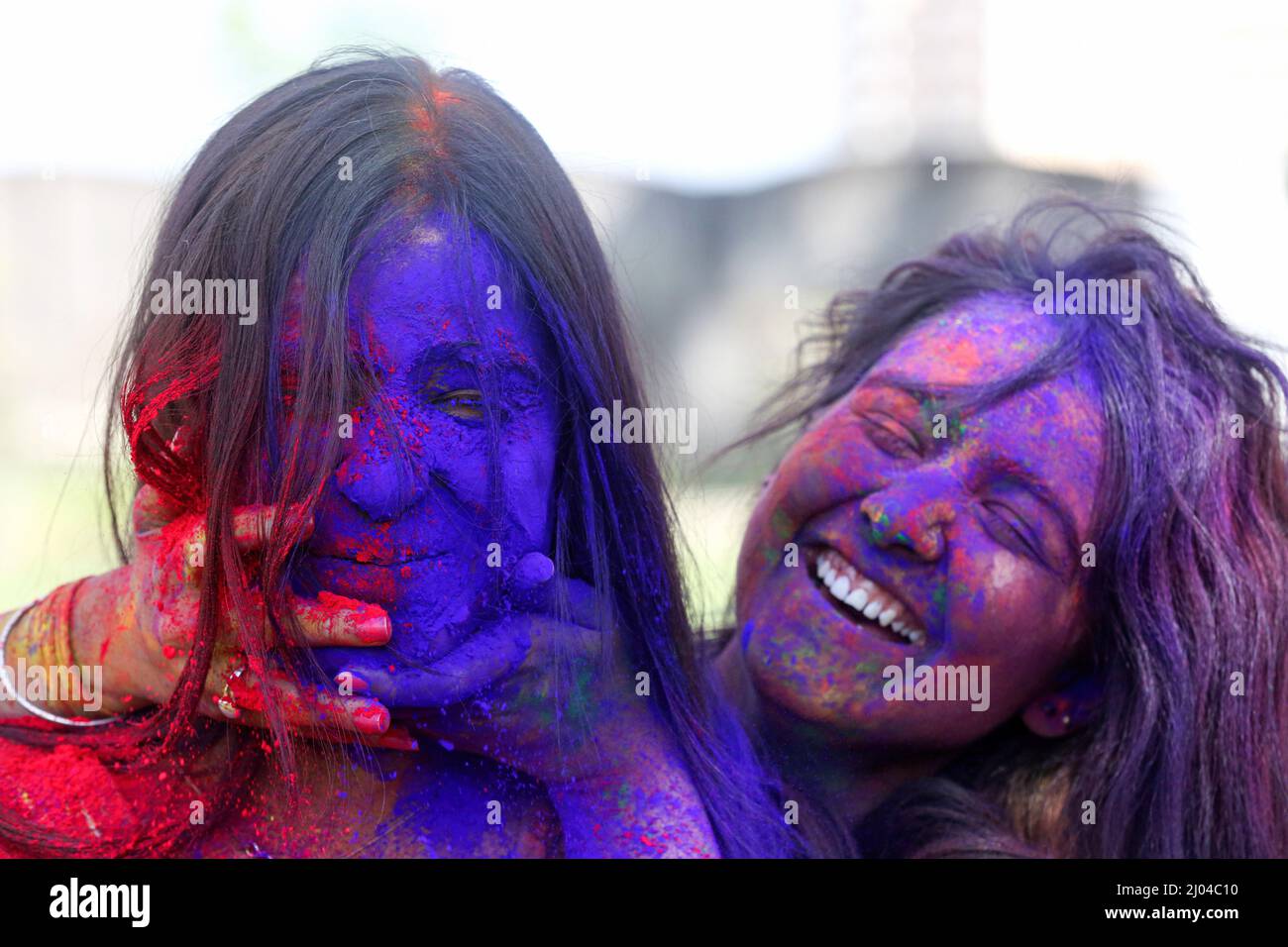 Indian young women apply colors to each other ahead of the Holi ...