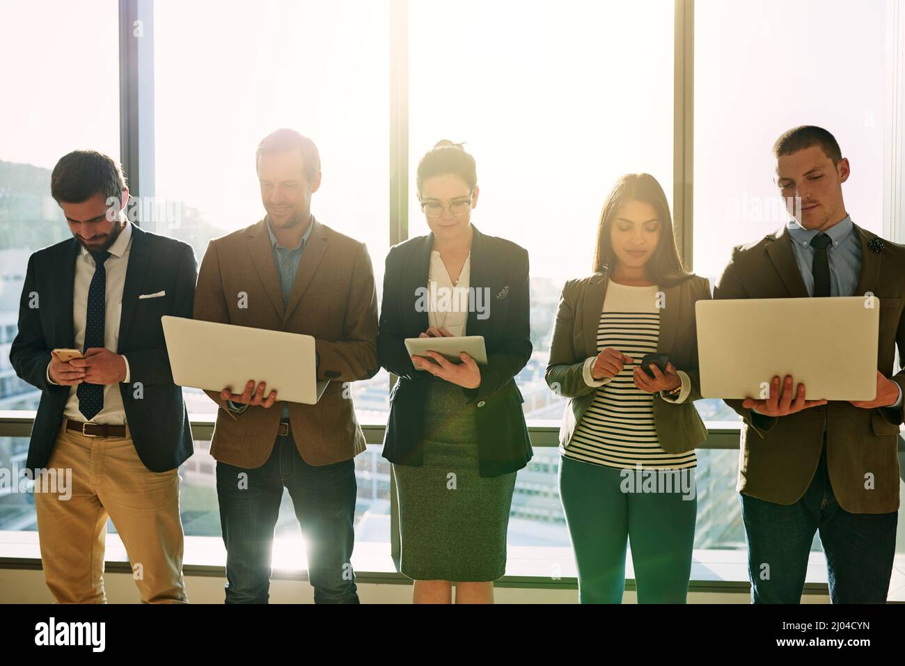Working wireless. Cropped shot of a group of businesspeople using ...