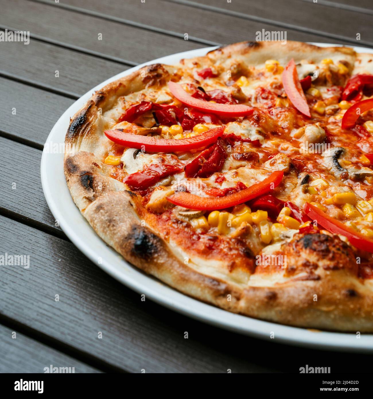 Serving of delicious fresh Italian pizza with corn, pepper, and ...