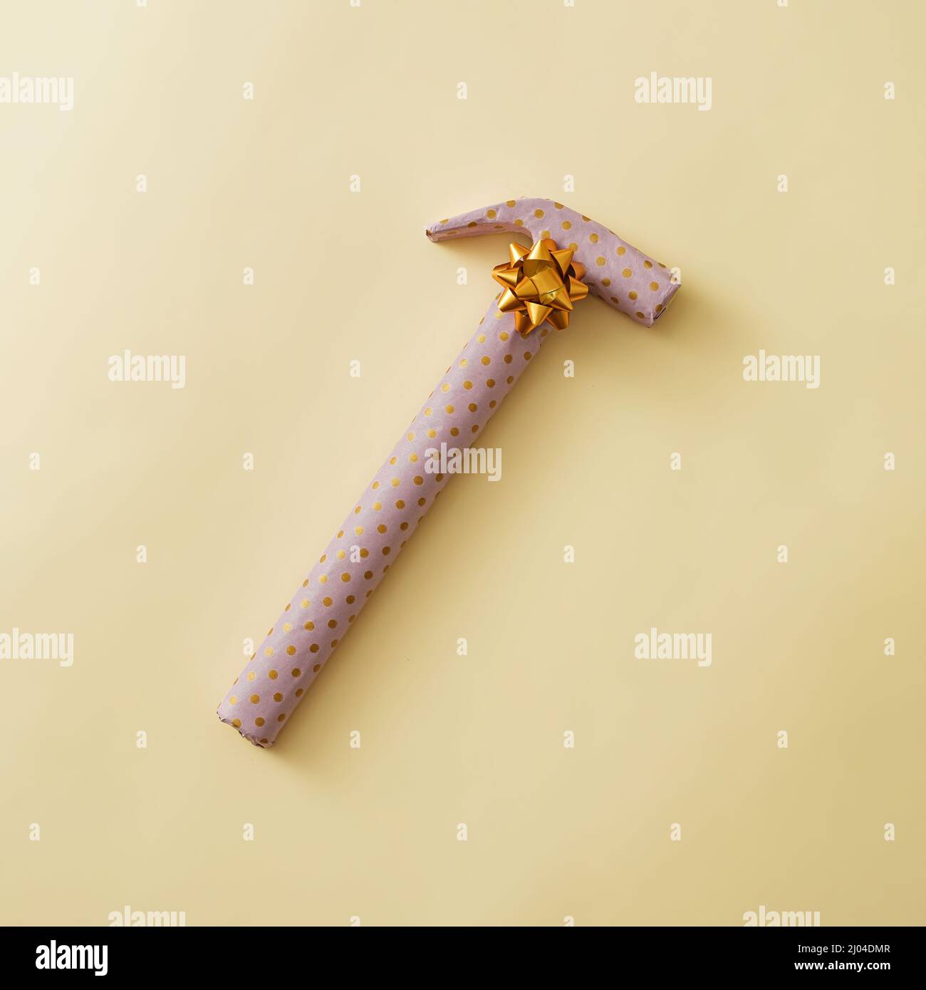 Gift wrapped hammer in yellow polka dot paper decorated with a gold ...