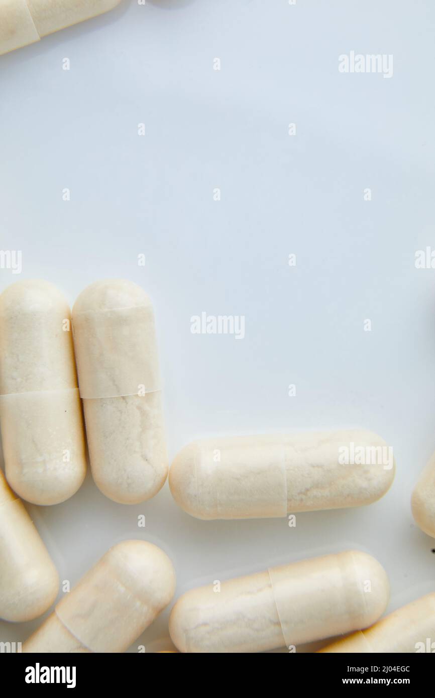 Flat lay macro White beige capsule pills, tablets, top view, close up ...
