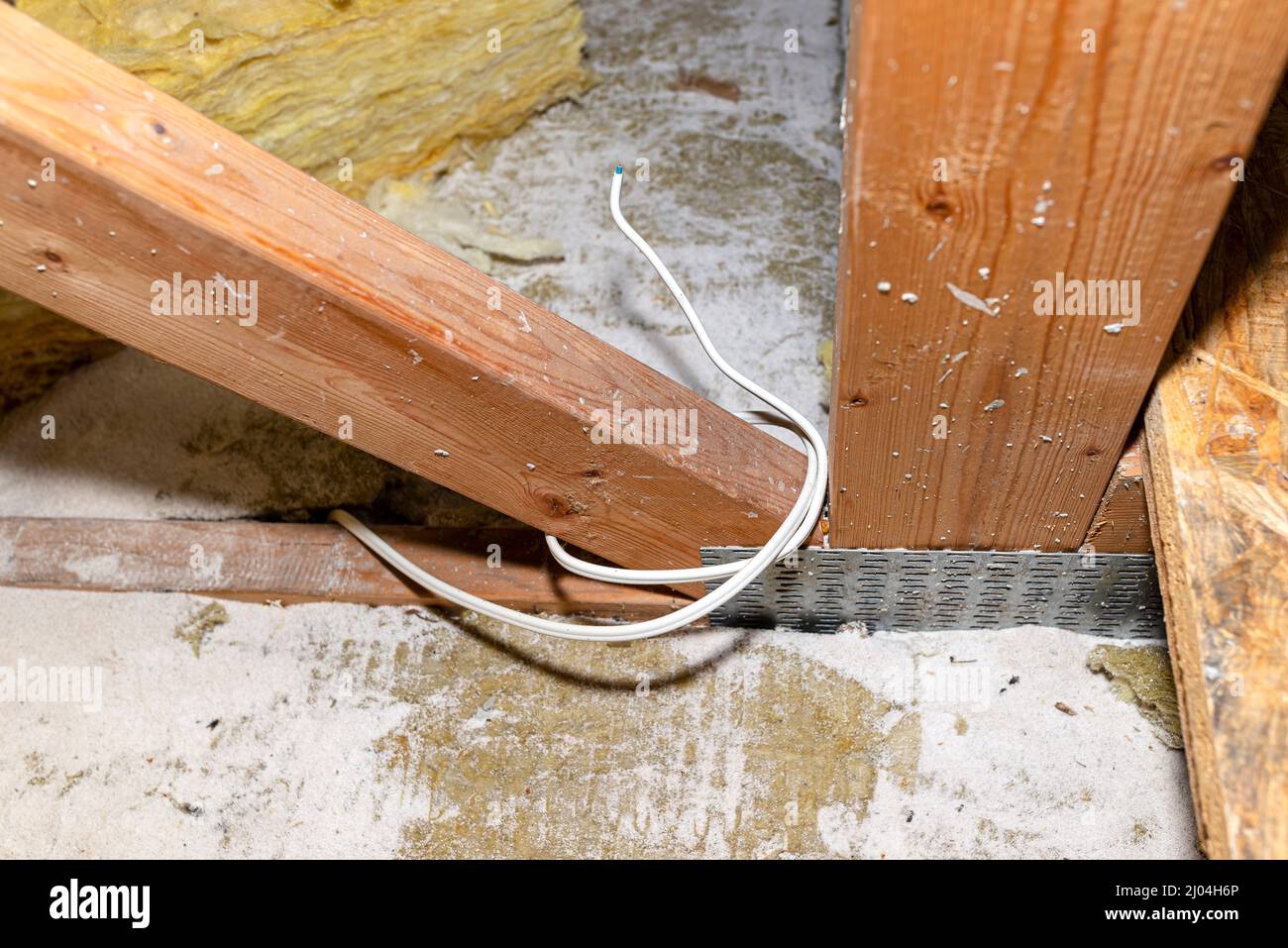 Electric cable for lighting wrapped on roof trusses in the attic of the ...