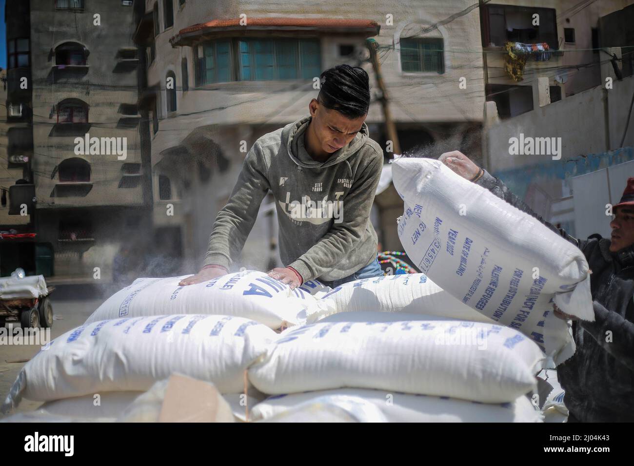 Gaza, Palestine. 16th Mar, 2022. A Palestinian vendor loads bags of ...