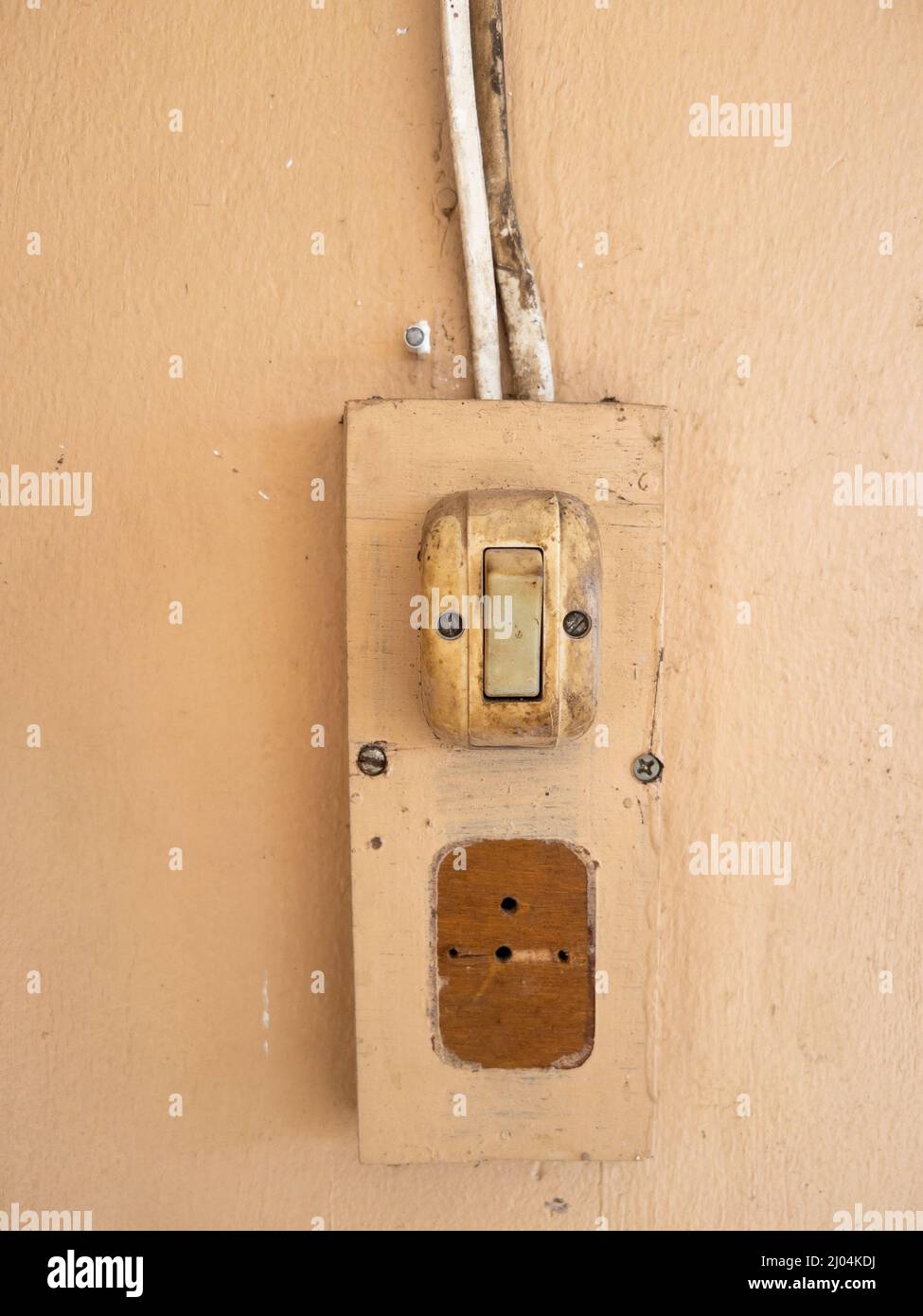 The vintage electric switch for the light bulb on the concrete wall of ...