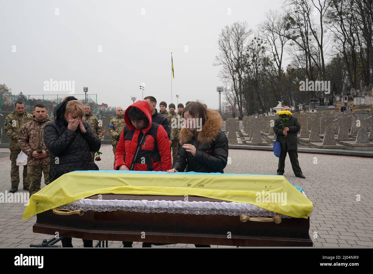 Lviv, Ukraine. 16th Mar, 2022. Family members mourn over the flagged ...