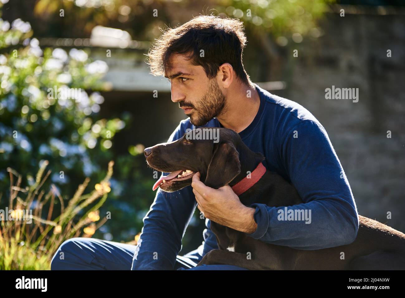 young man hugging his dog Stock Photo - Alamy