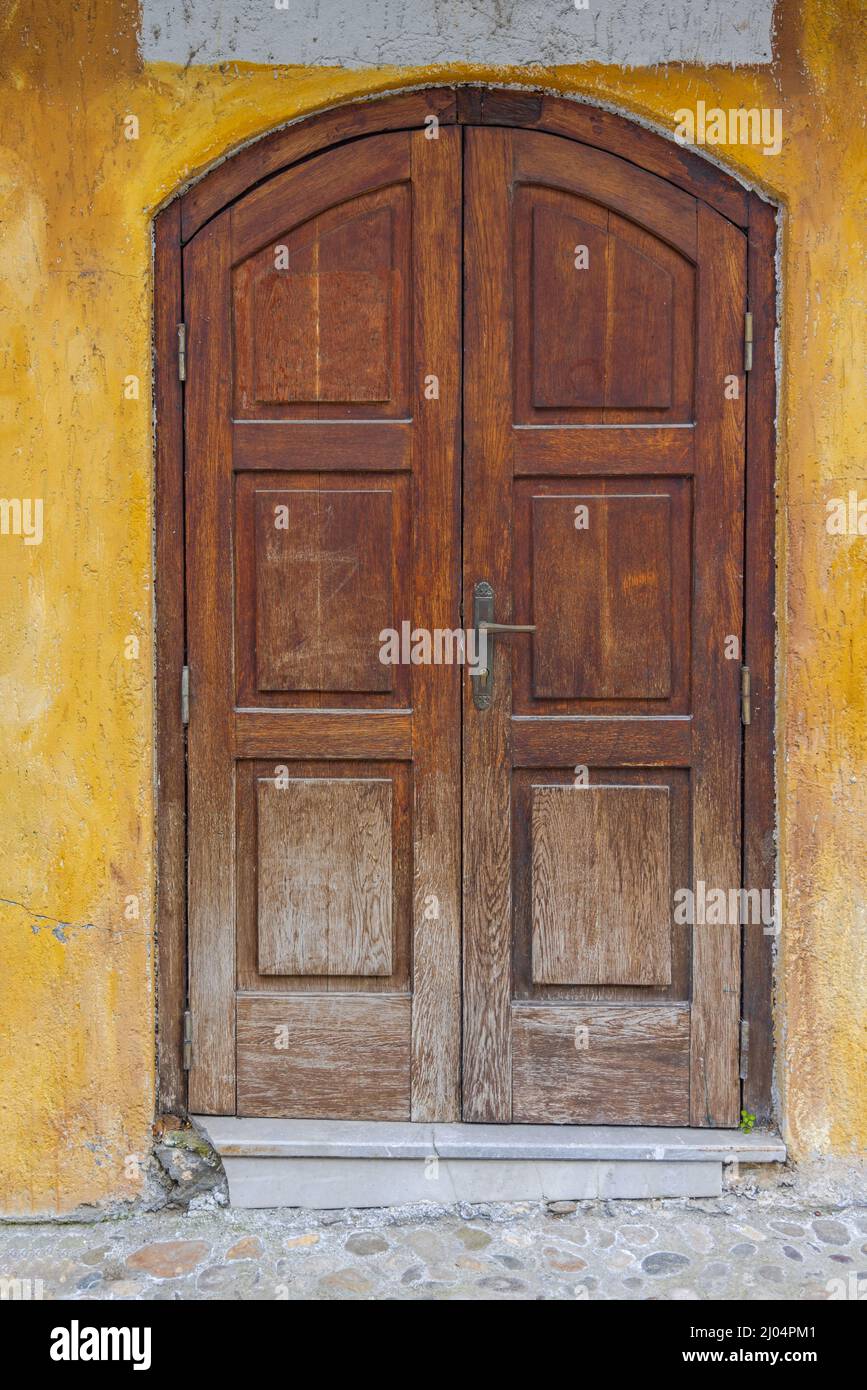 Rustic Style Wood Arch Door at Old Yellow House Stock Photo - Alamy
