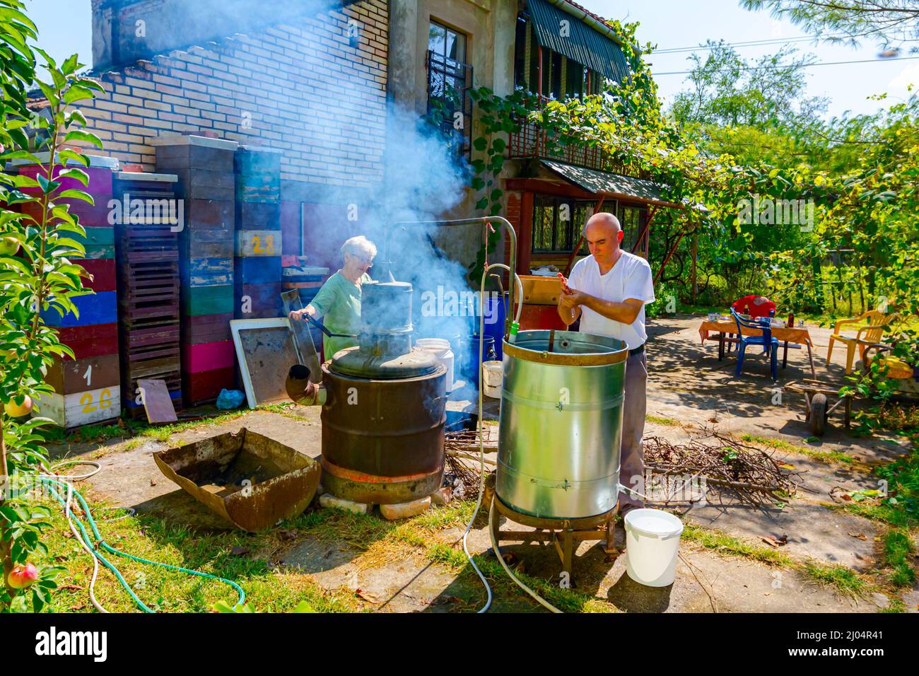 Man washes his hands in the distiller while woman is manually turning ...