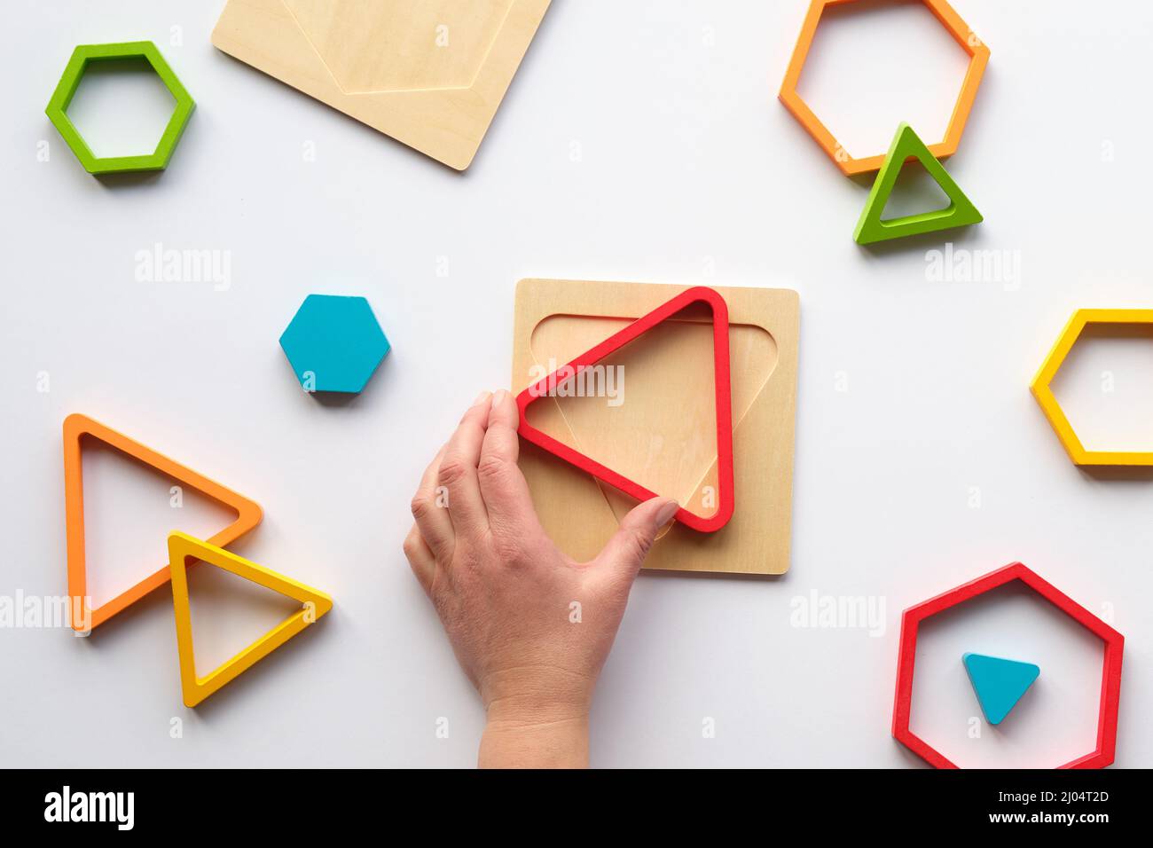 Hand with triangle. Nested wood triangles and hexagons, concentric ...