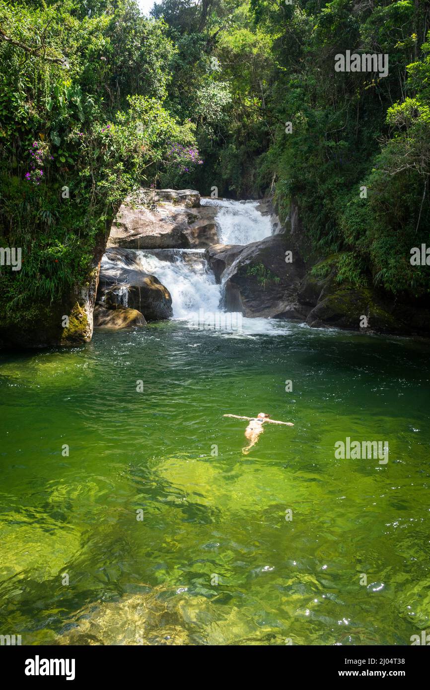 Beautiful view to woman swimming on green pool on rainforest waterfall ...