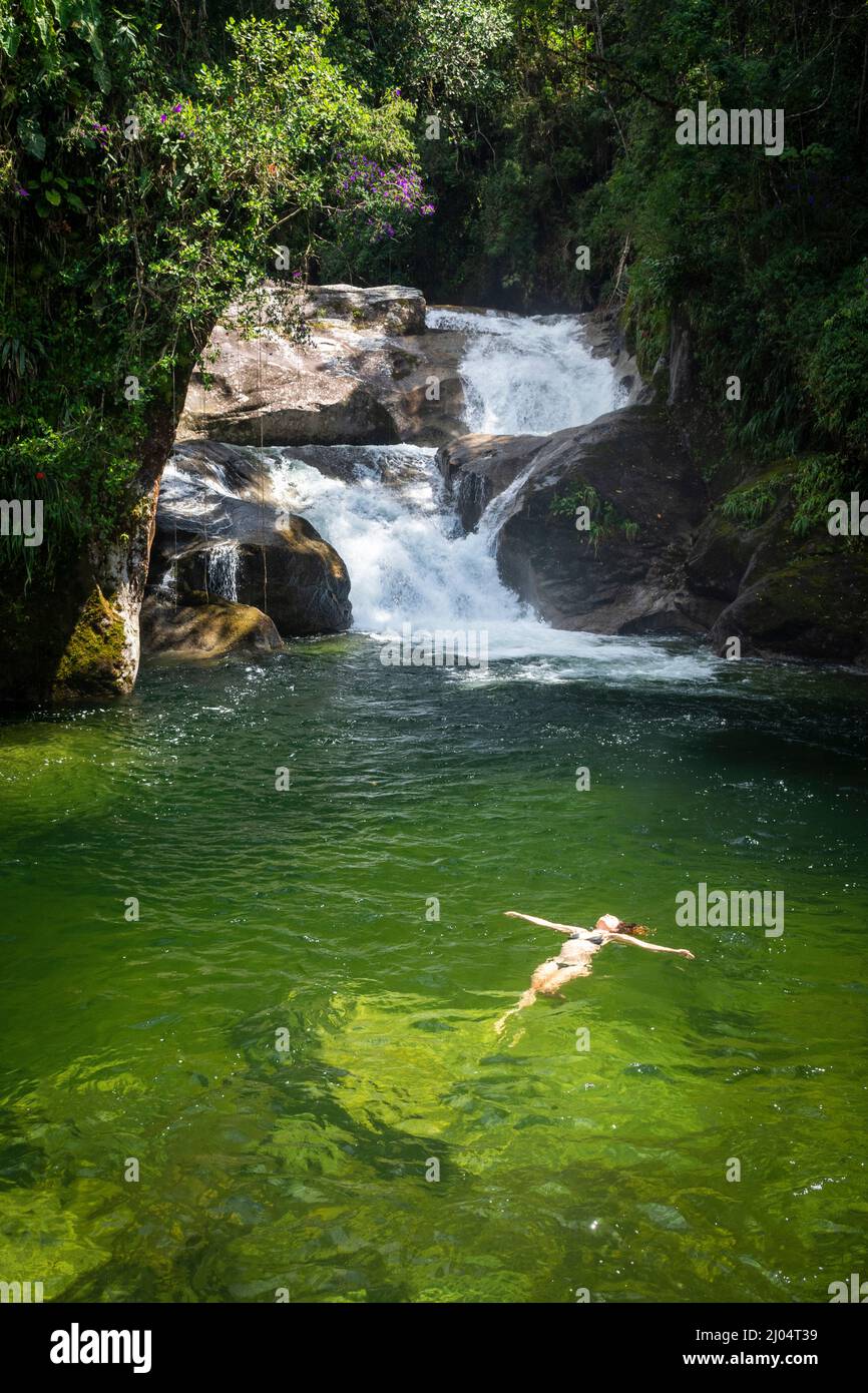 Beautiful view to woman swimming on green pool on rainforest waterfall ...