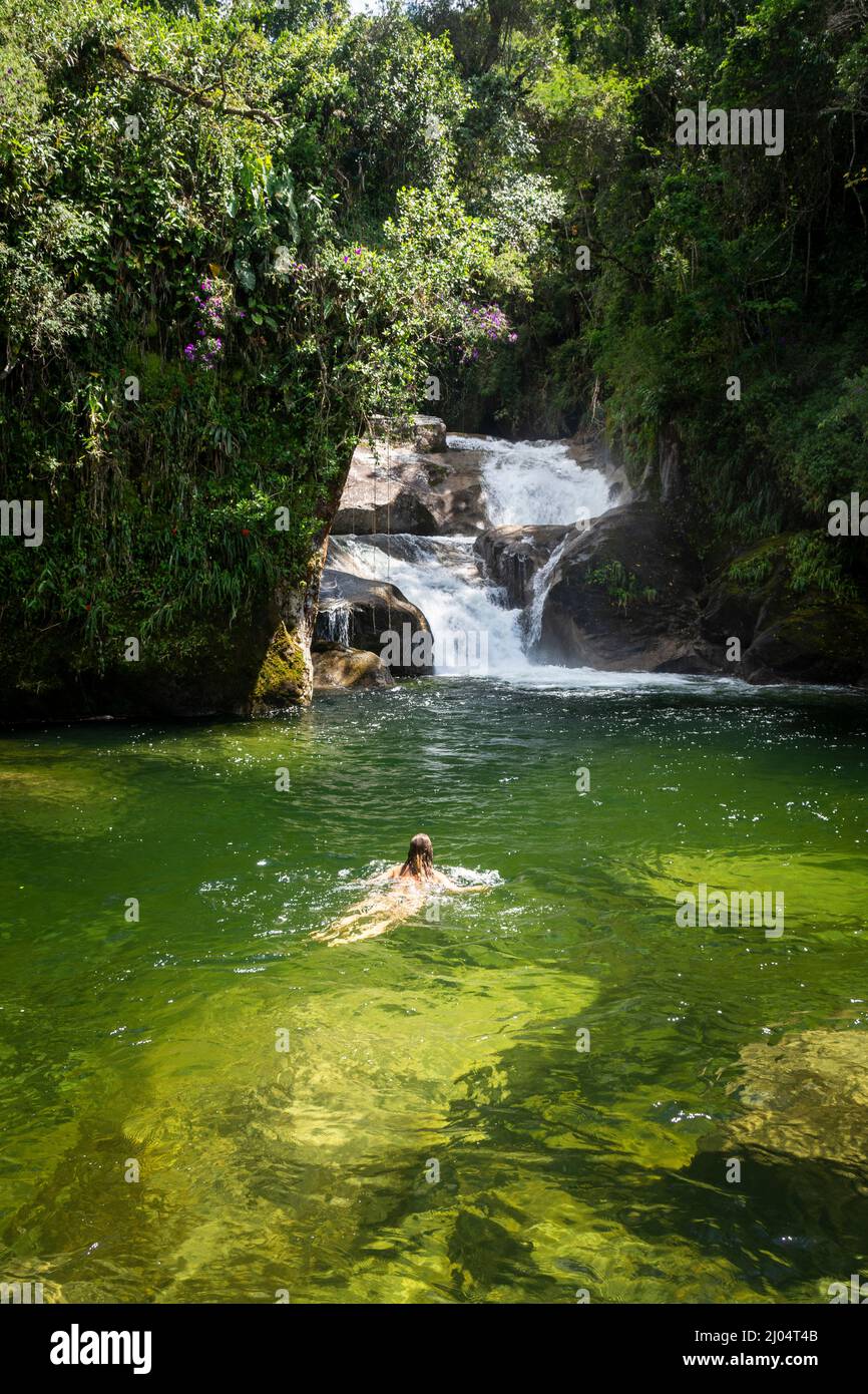 Beautiful view to woman swimming on green pool on rainforest waterfall ...