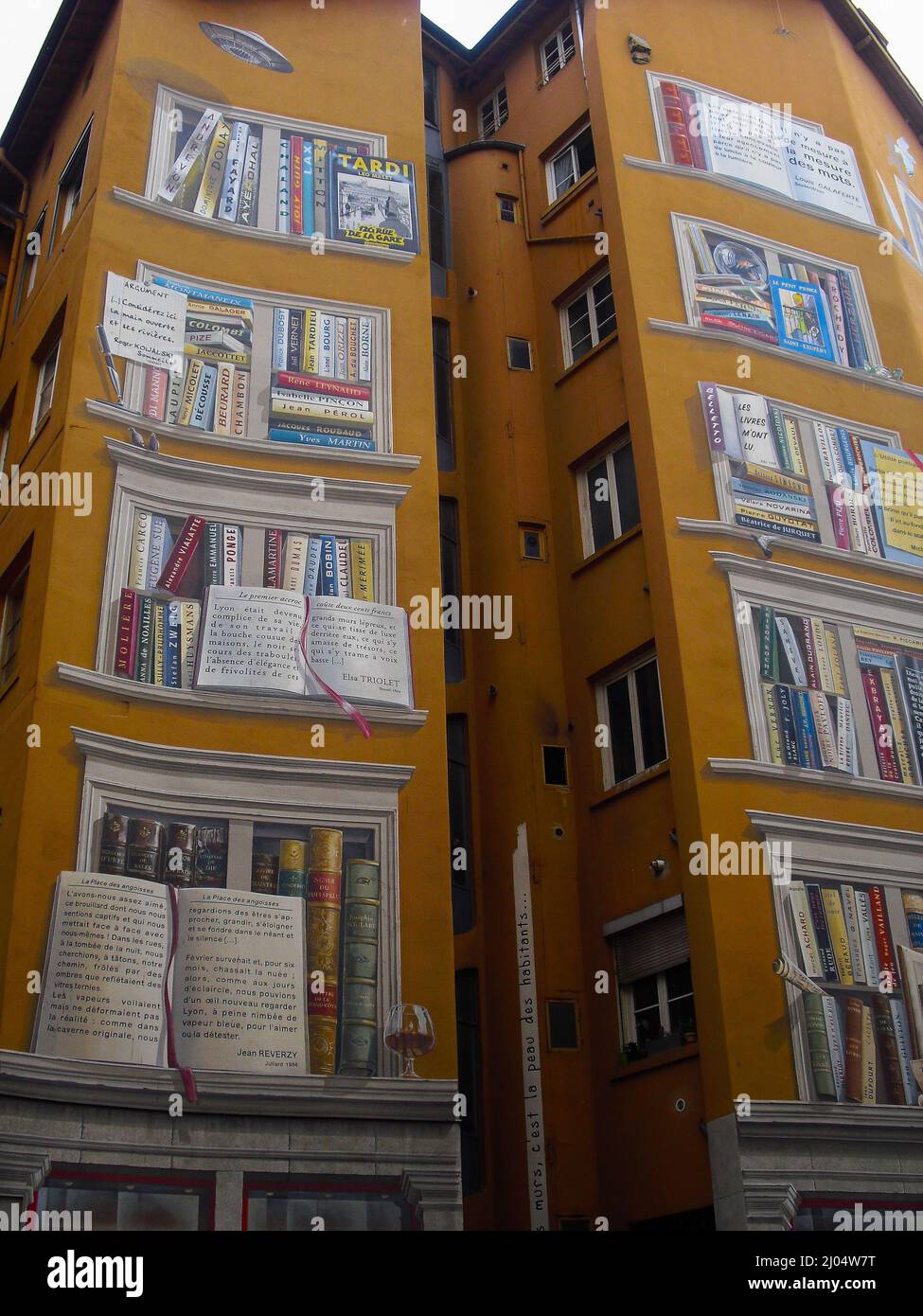 Vertical shot of an orange building painted with books and bookshelves ...