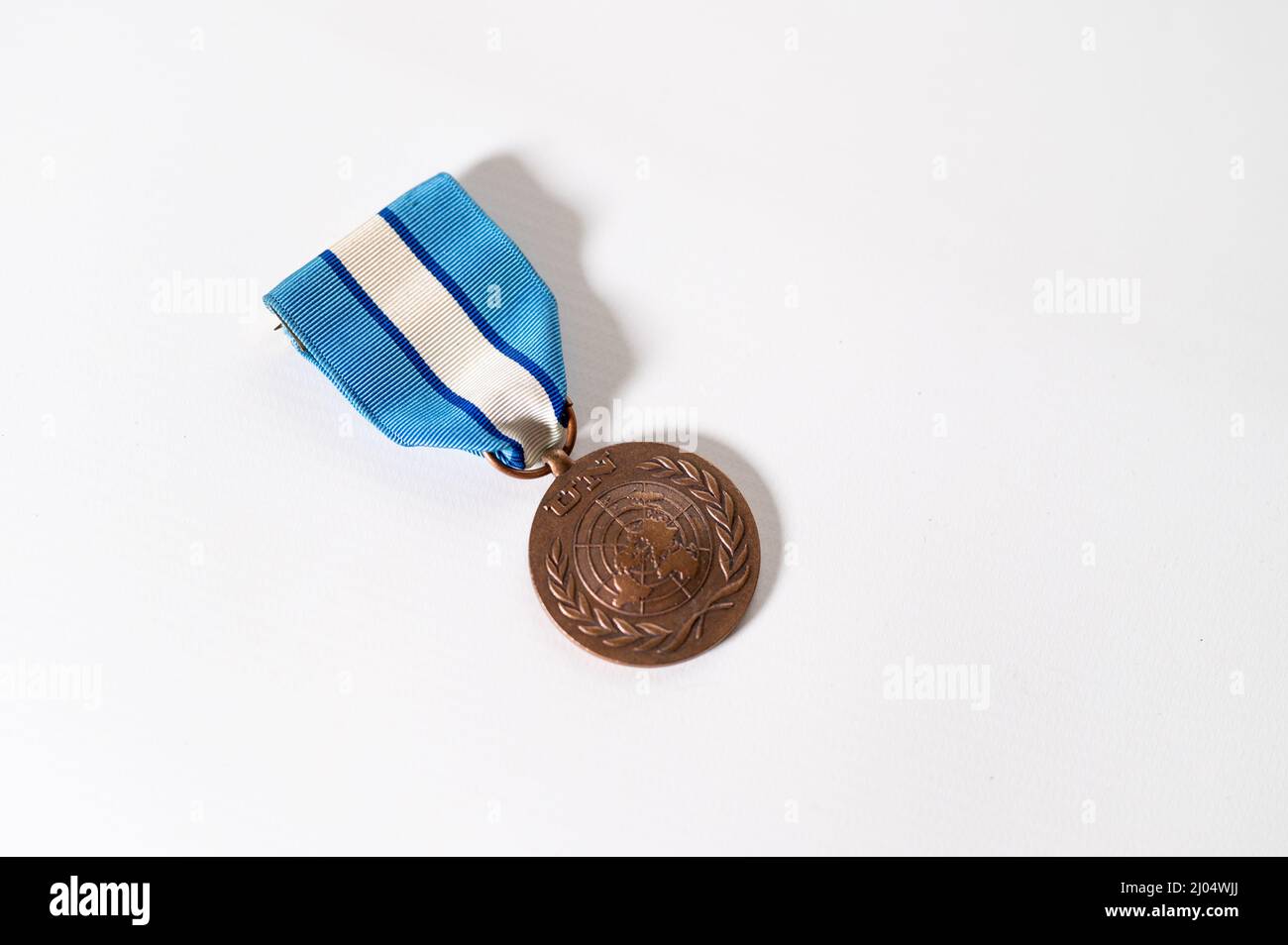 Overhead shot of United Nations Peacekeeper's medal on a white ...