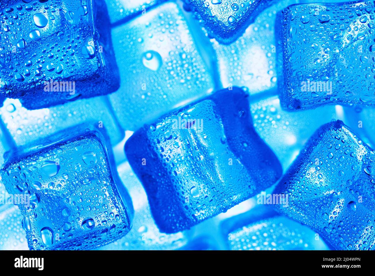 Ice cubes with blue backlight in the freezer close-up in full screen ...