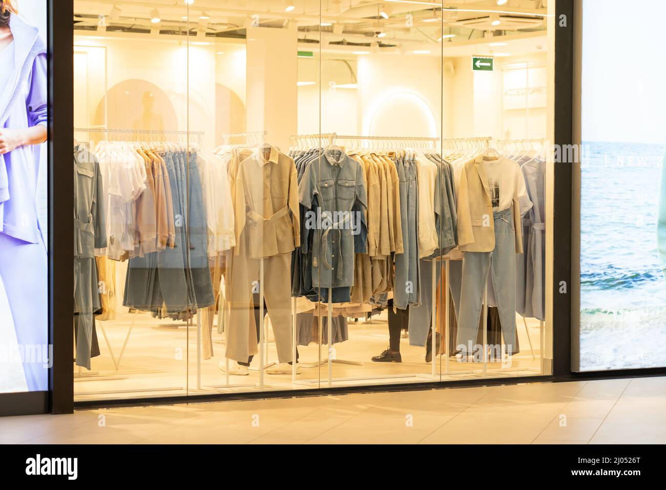 Showcase with female clothes in clothing store, nobody. Coats, jackets ...