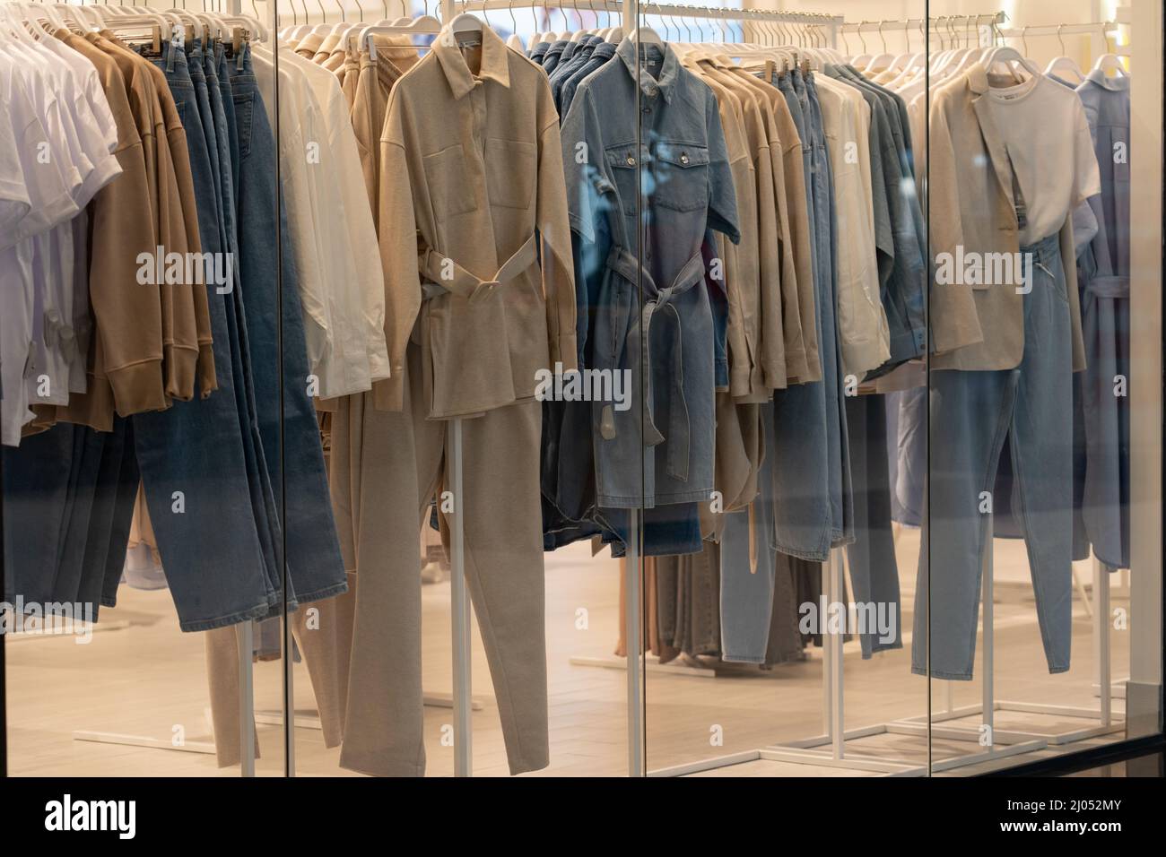 Showcase with female clothes in clothing store, nobody. Coats, jackets ...