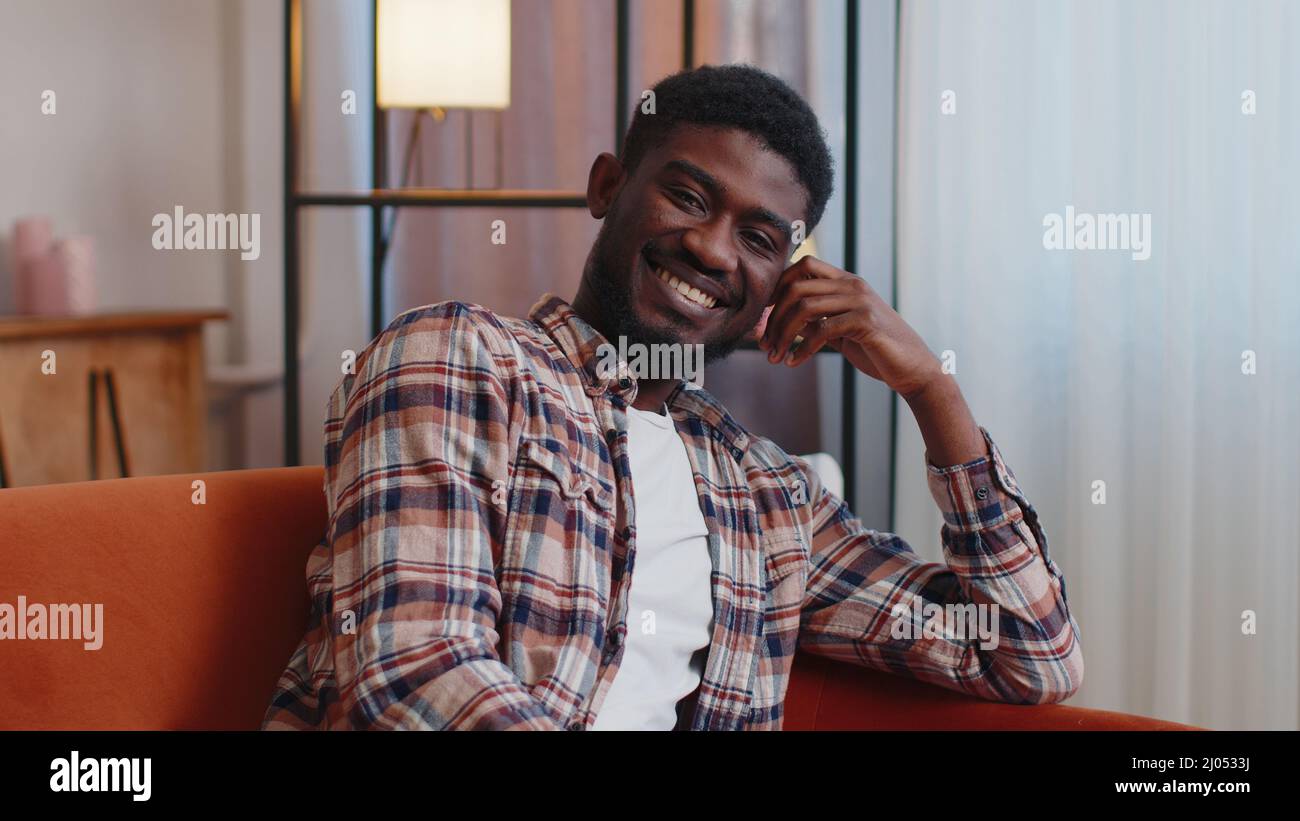 Happy calm young african american bearded man smiling looking away ...
