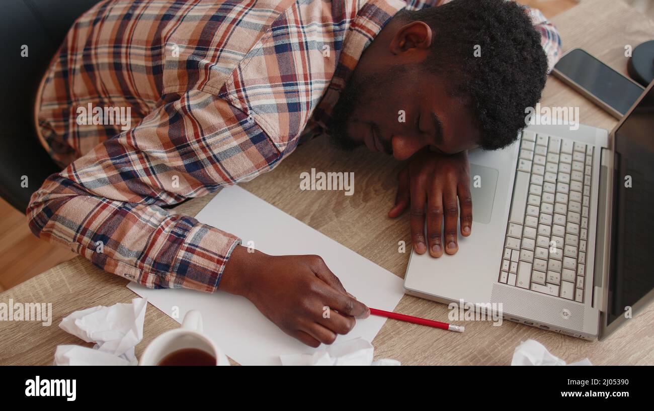 Tired man at home office falling asleep on table with laptop computer ...