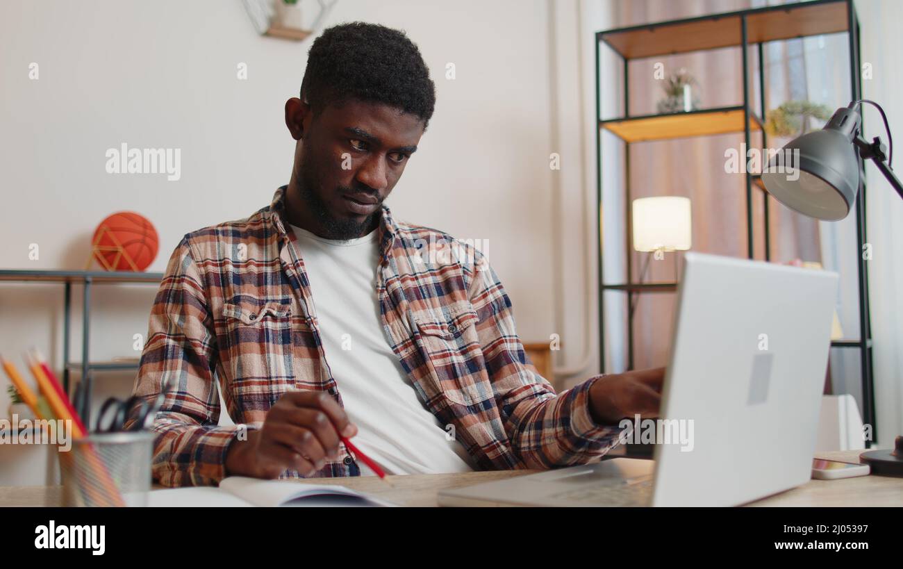 Young man guy using laptop computer sitting at table working, online ...