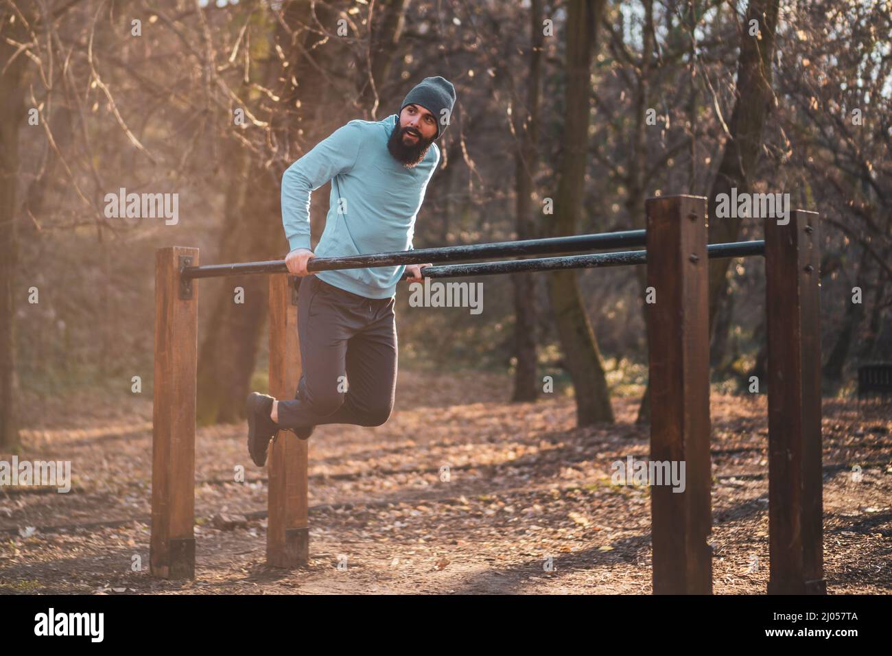 Man enjoys exercise push- ups on parallel bars in the park Stock Photo ...