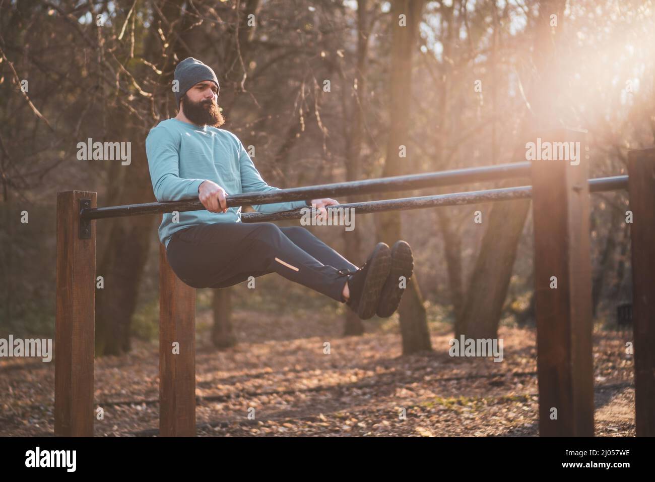 Man enjoys exercise push- ups on parallel bars in the park Stock Photo ...